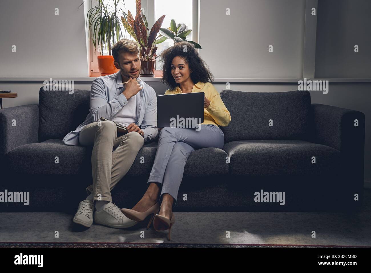 Smiling lady staring at her male coworker Stock Photo - Alamy