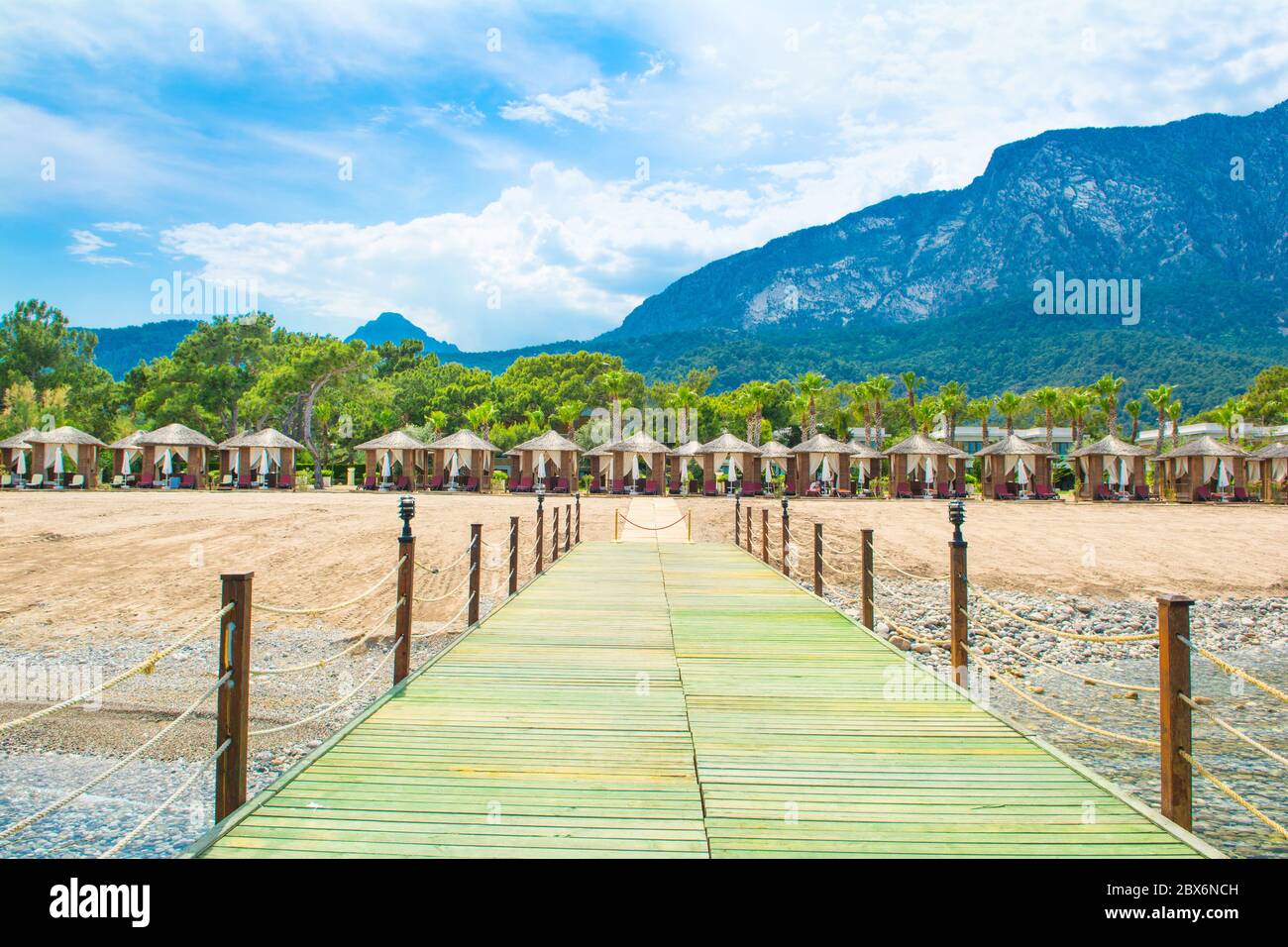Wooden beach pavilions on the shore of a sandy beach - the ...