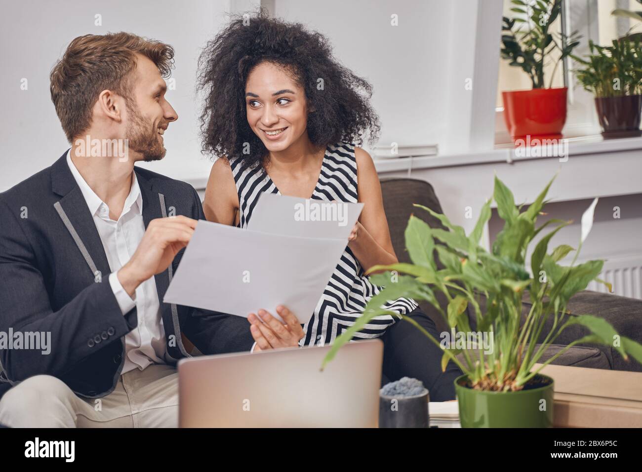 Two cheerful employees looking at each other Stock Photo - Alamy