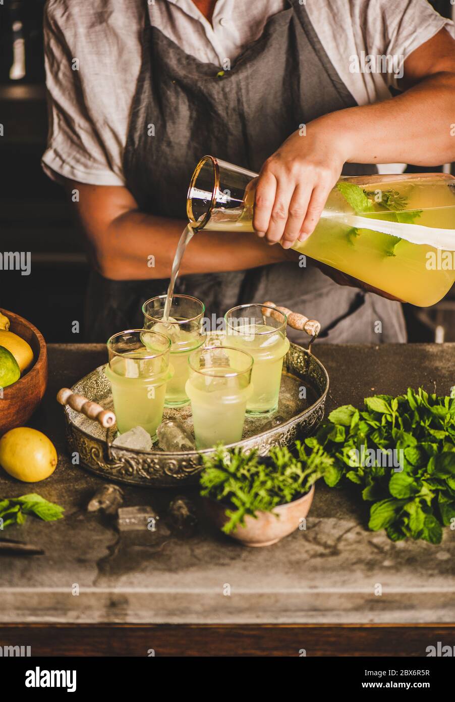 Hands of woman making fresh homemade lemonade over kitchen counter ...