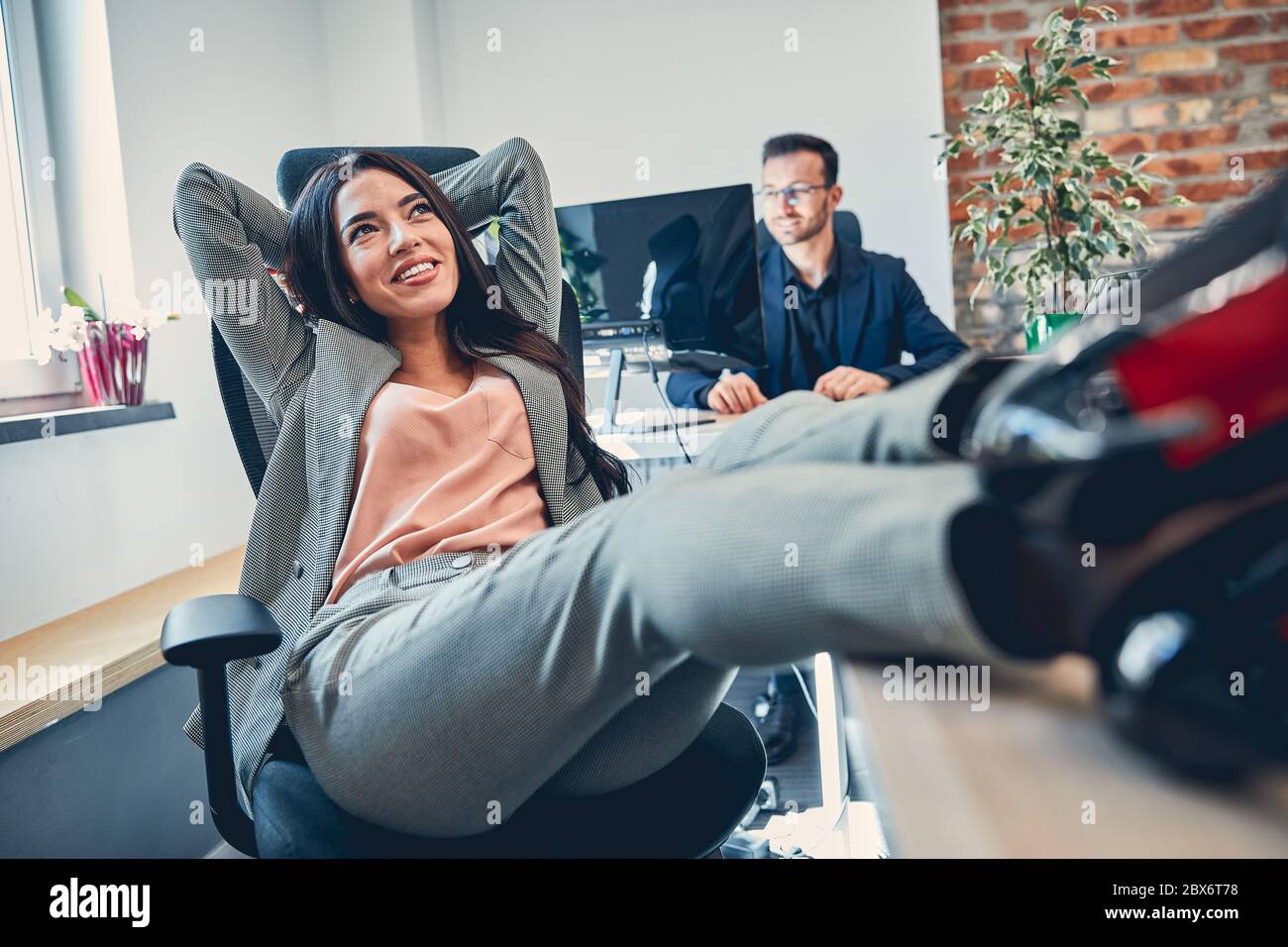 Happy managers sitting at the table at workplace Stock Photo - Alamy