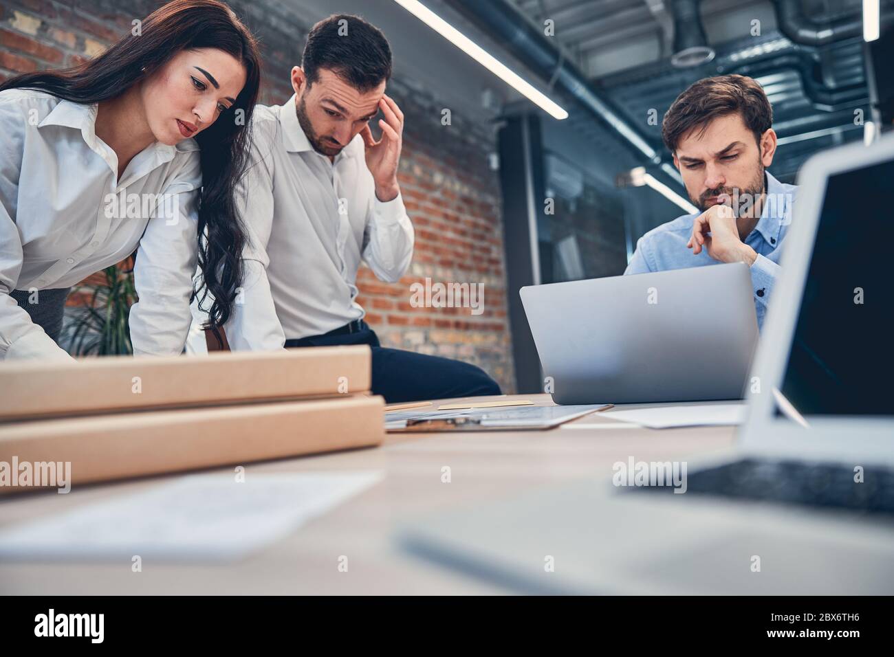 Young co-workers working on startup project together Stock Photo - Alamy