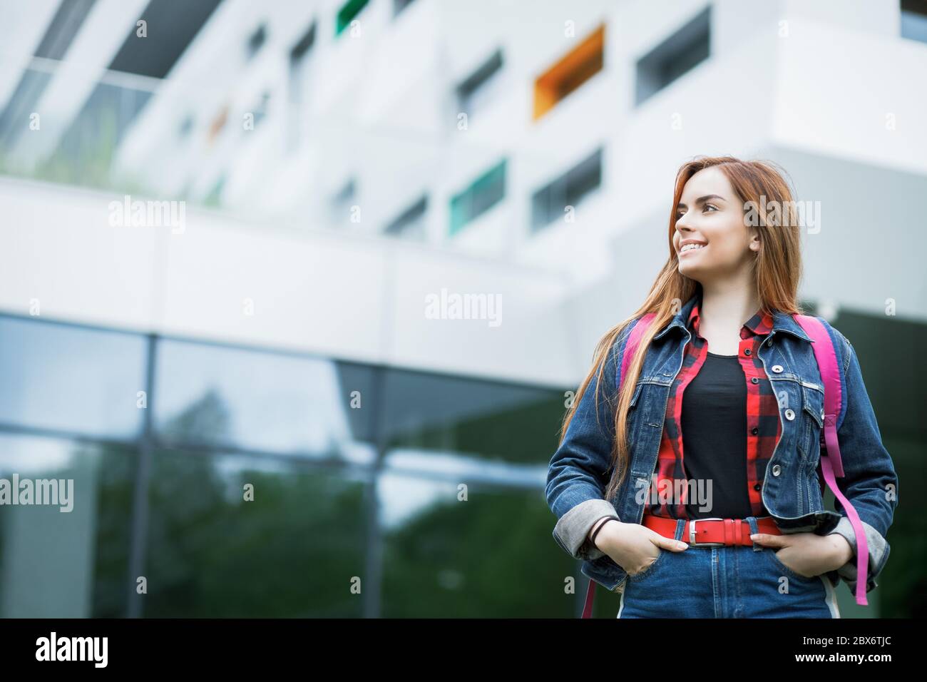 Portrait of a beautiful female student on campus building background ...