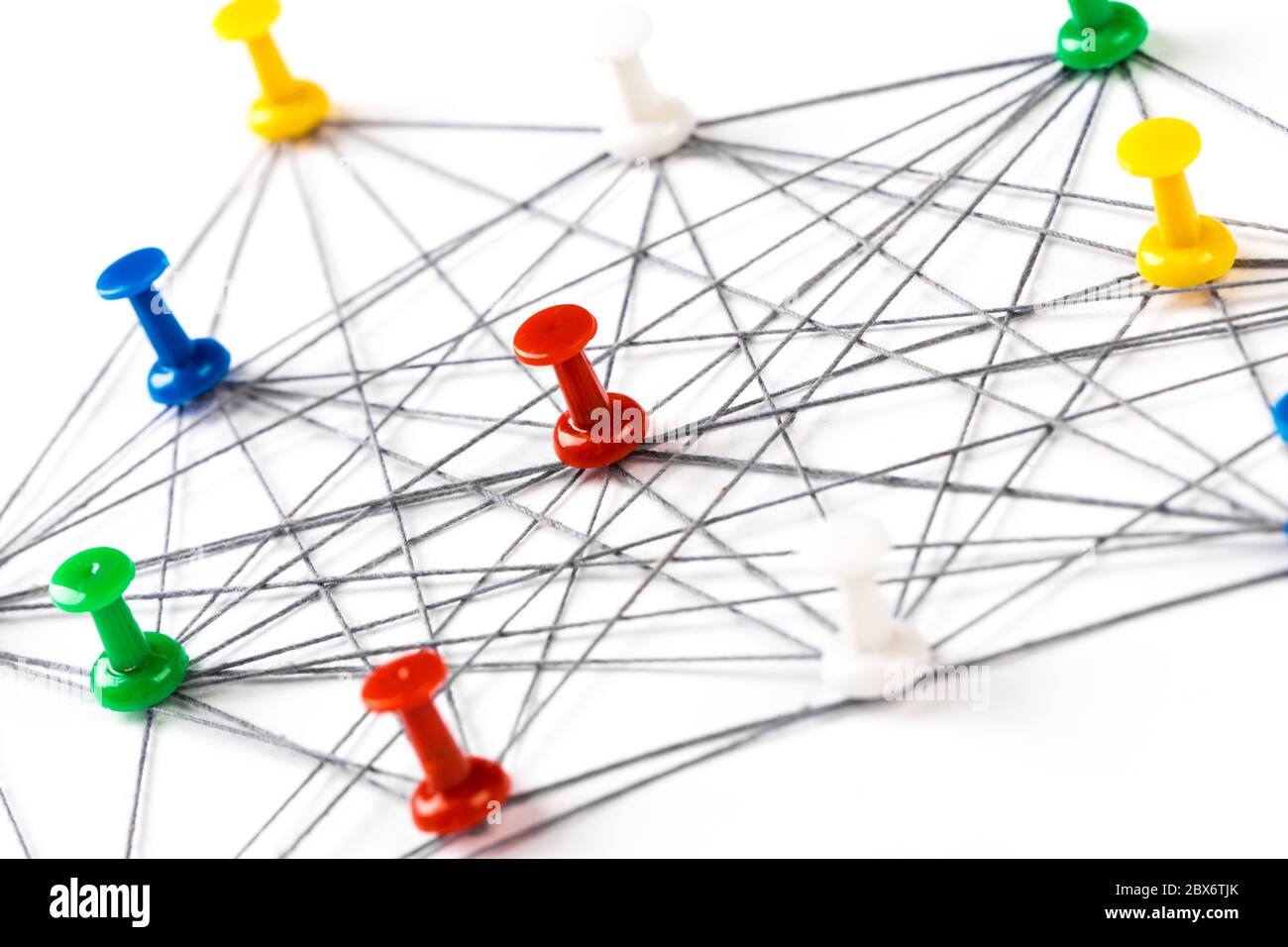 Network connection made from push pins and thread on blue background ...