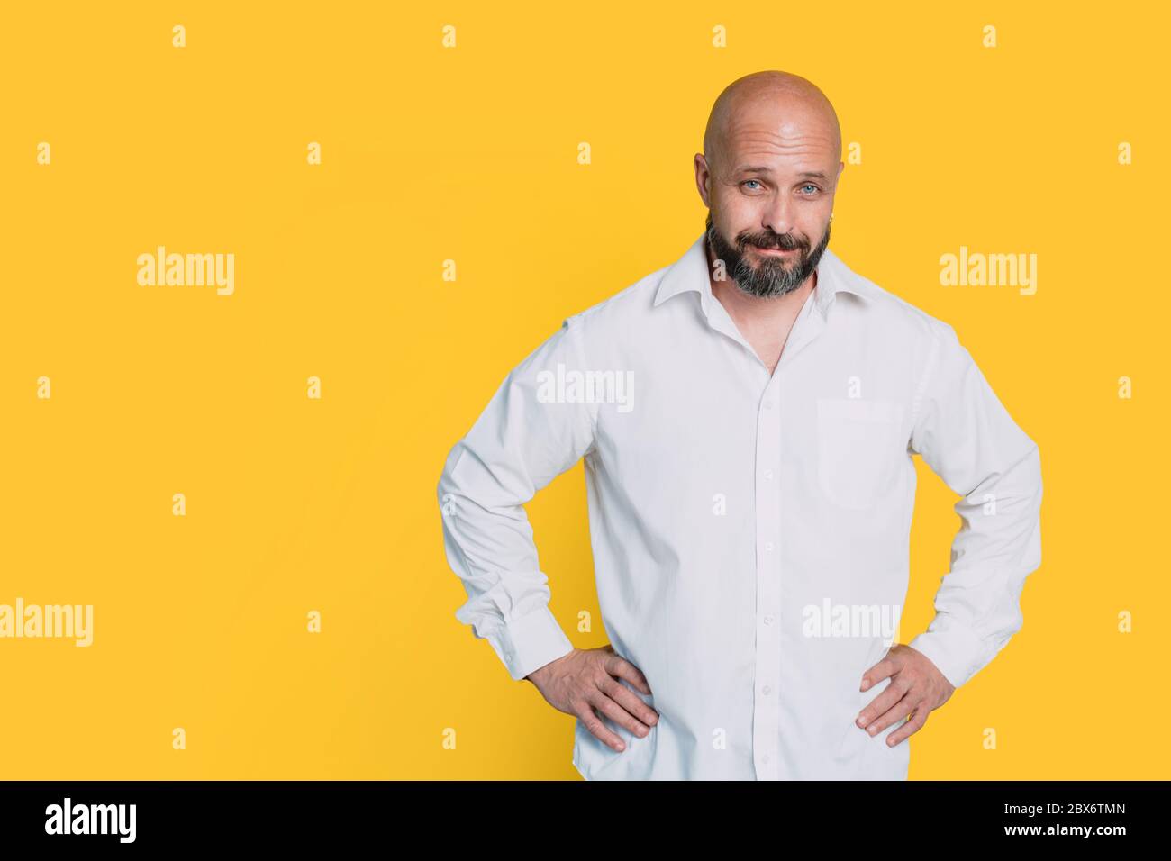 Handsome middle-aged man on yellow background looking at camera. with ...