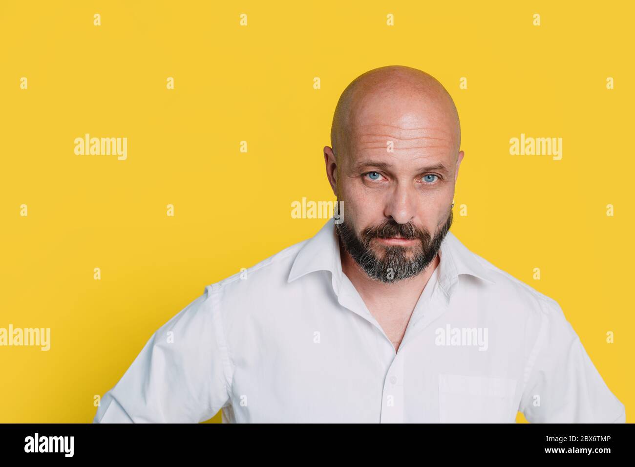 Serious middle-aged man with folded arms and a deadpan expression ...