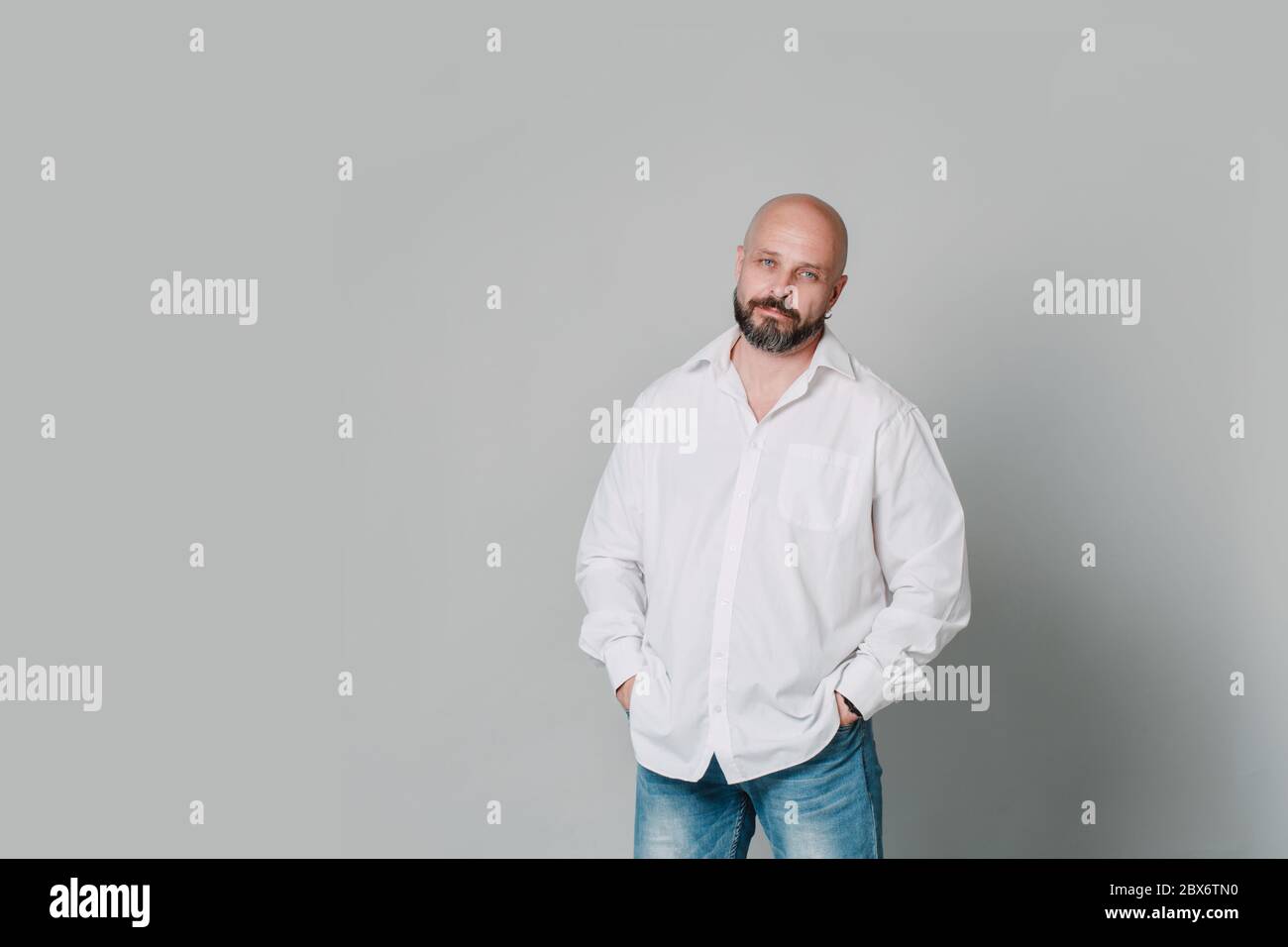 Handsome middle-aged man on grey background looking at camera. with ...