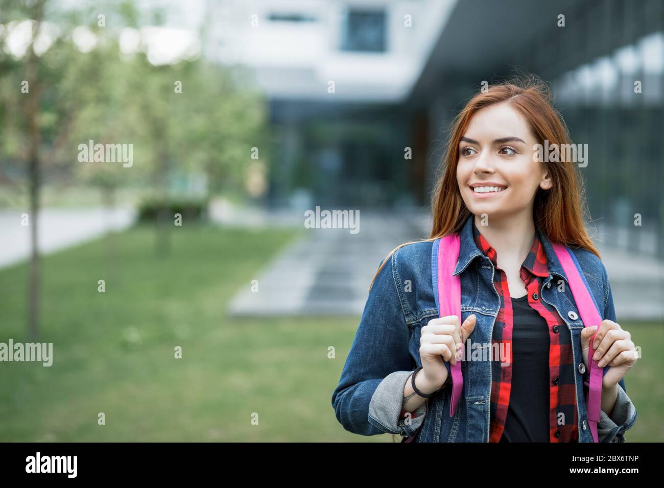 Portrait of a beautiful female student on campus building background ...