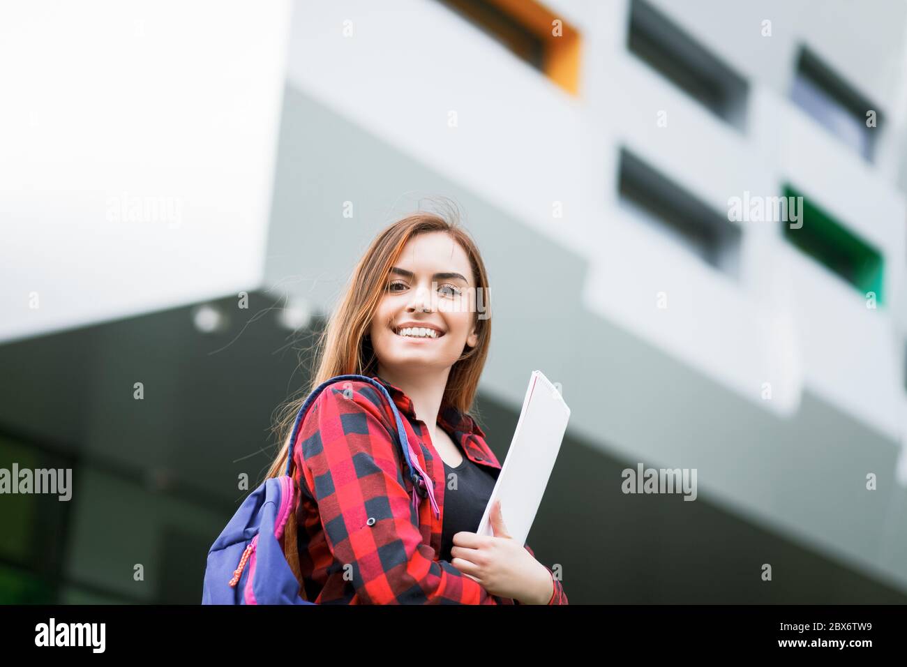 Portrait of a young girl student on the background of a university ...