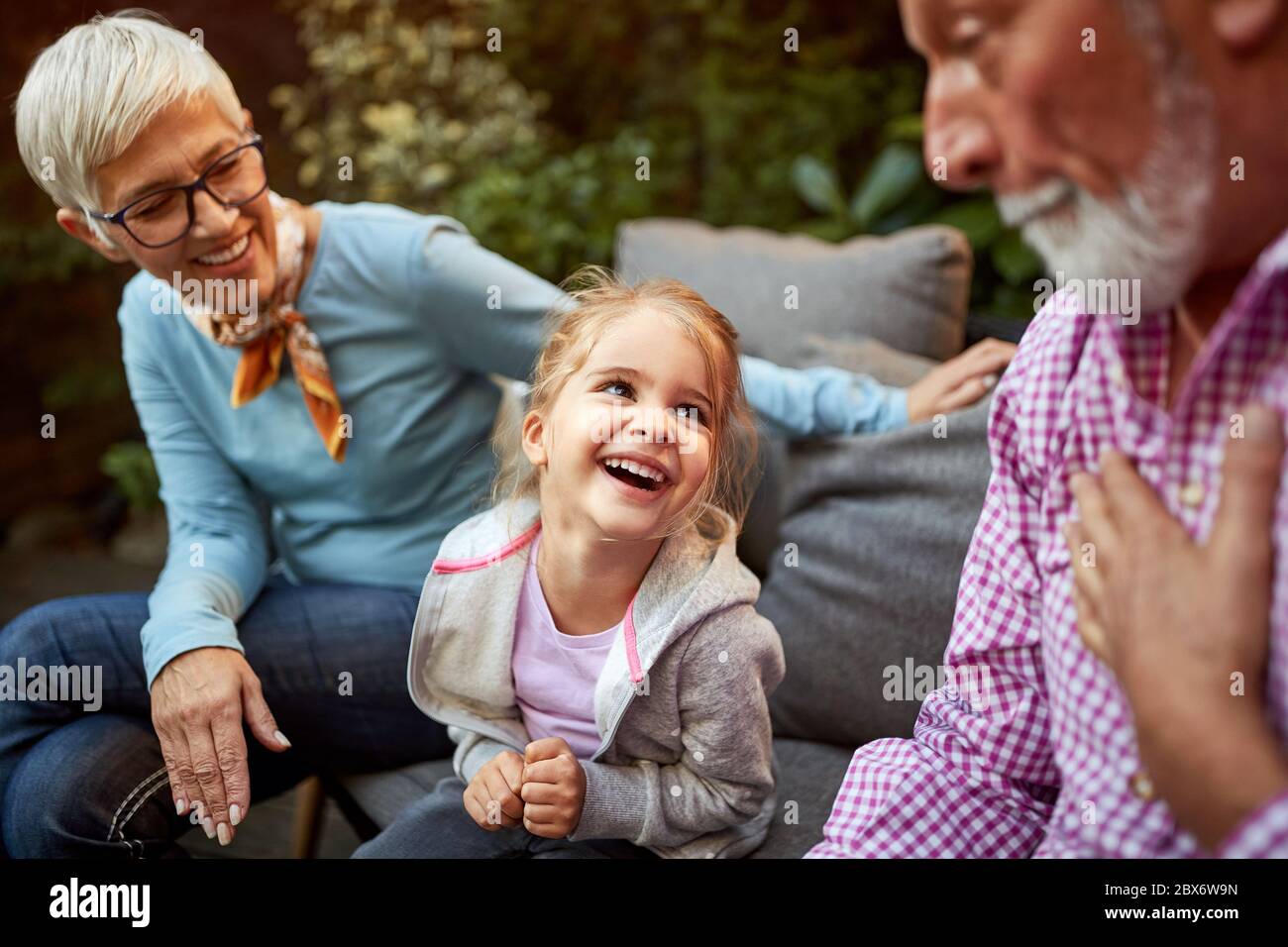 Cheerful female child having fun with grandparents Stock Photo - Alamy