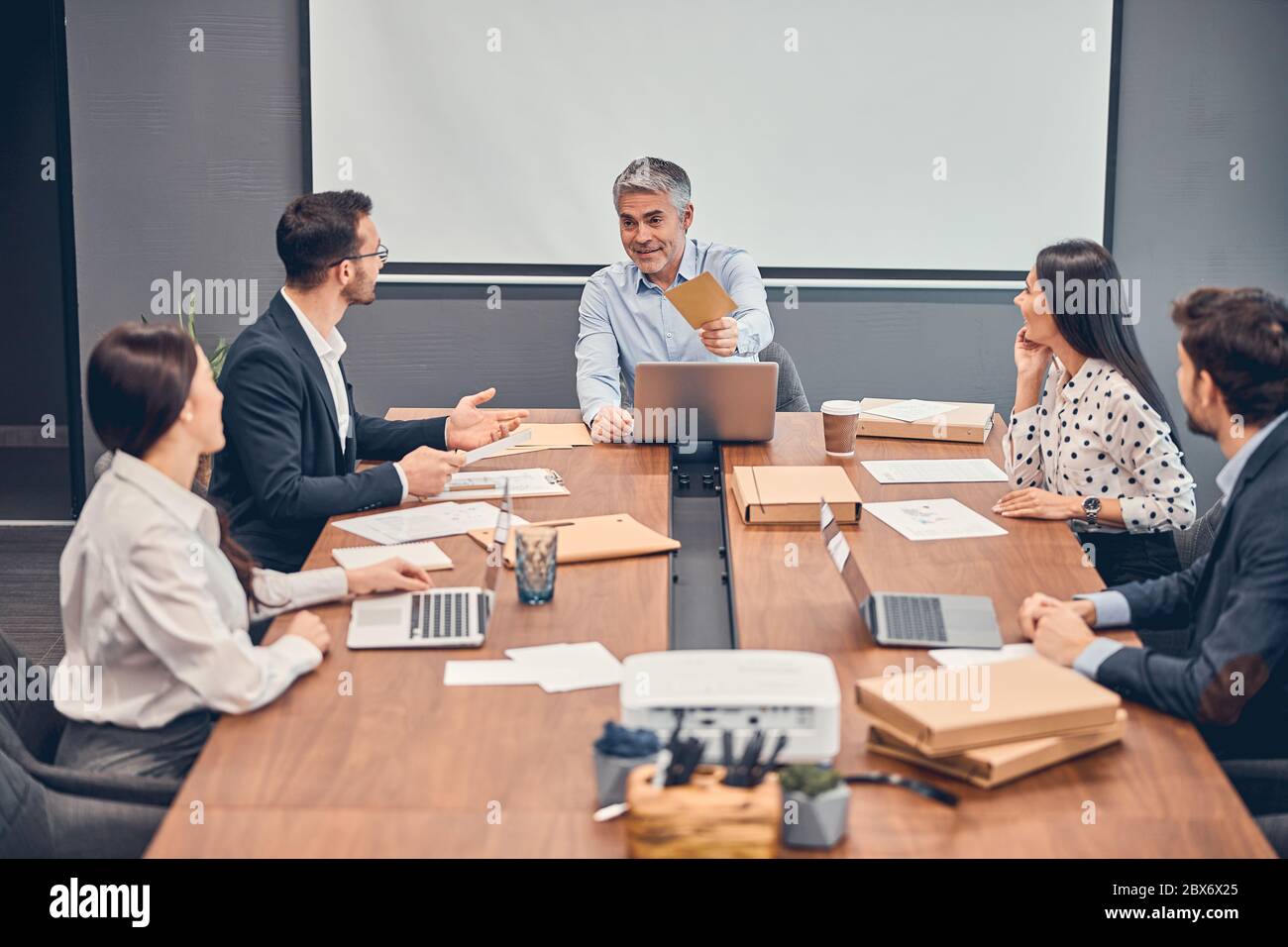 Happy co-workers discussing new startup project with boss in office ...