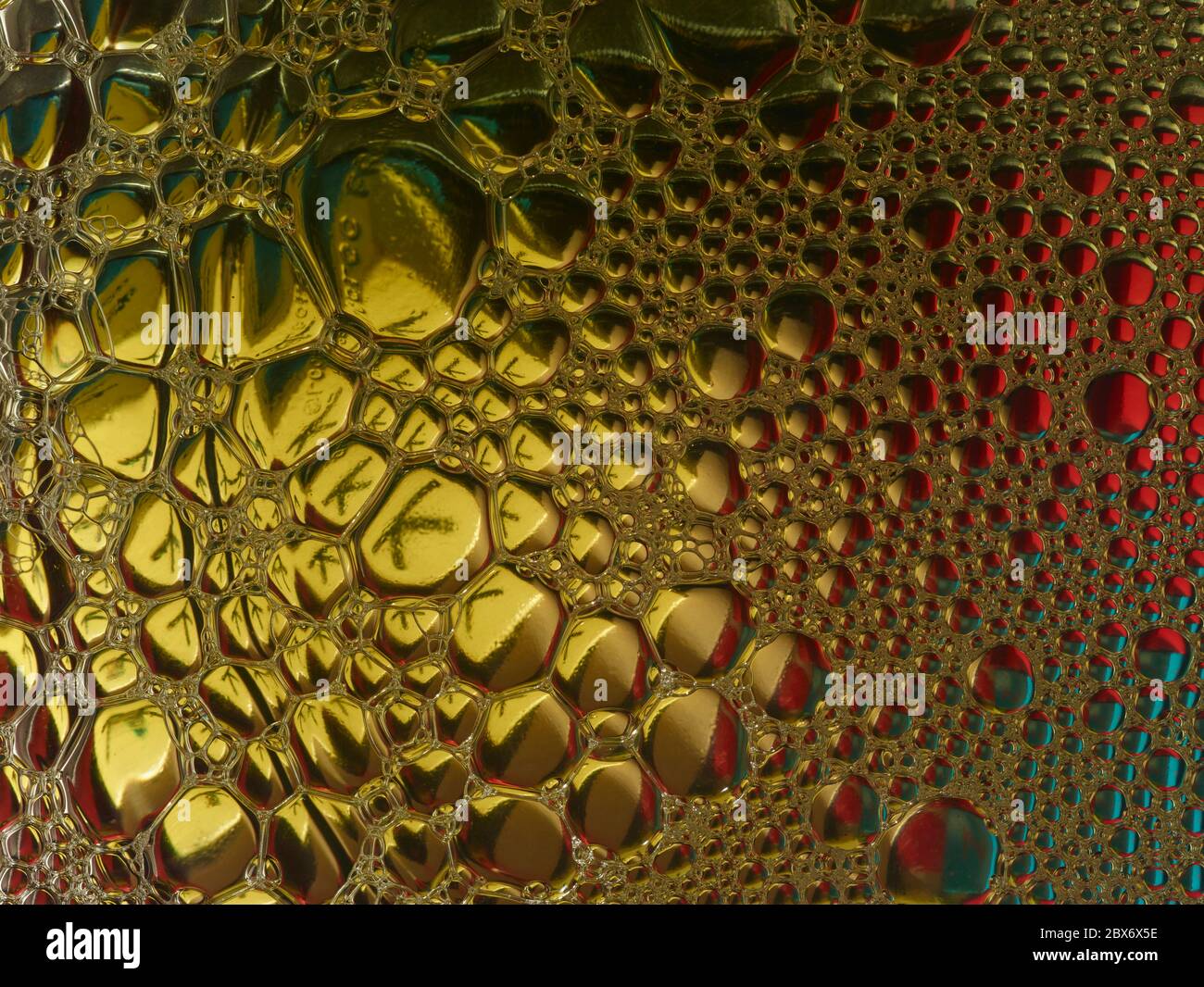 Conceptual close-up still-life of colourful bubbles on a liquid surface ...