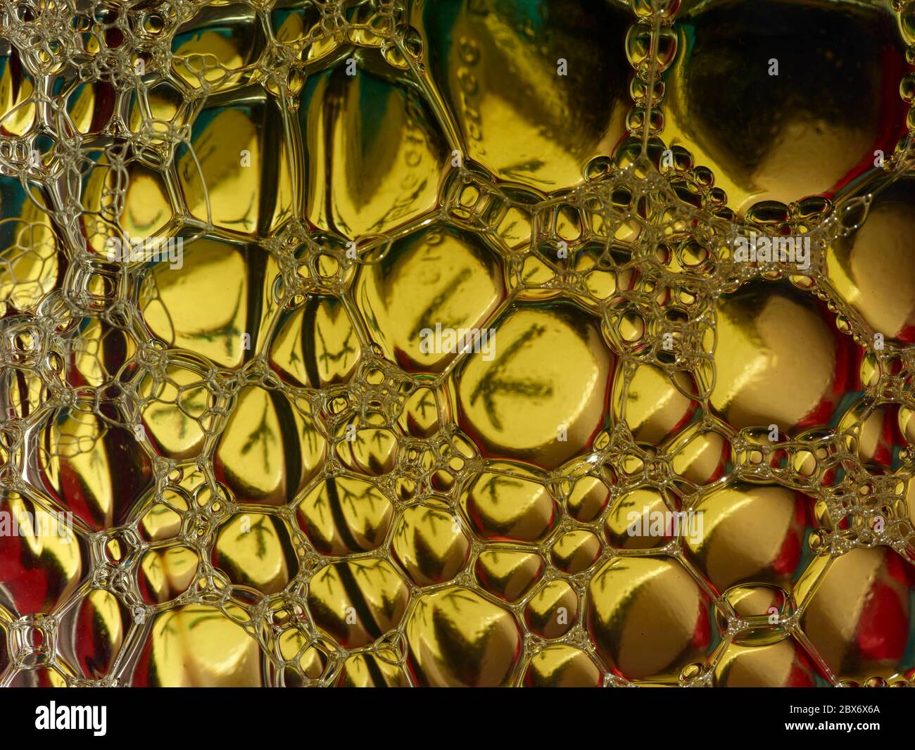 Conceptual close-up still-life of colourful bubbles on a liquid surface ...