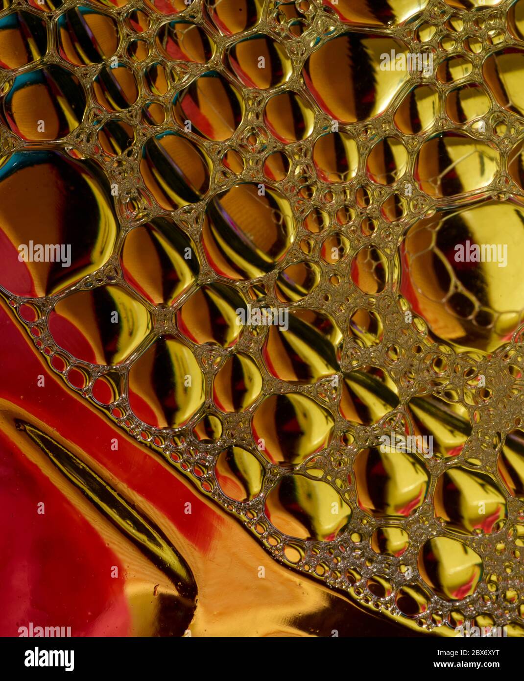 Conceptual close-up still-life of colourful bubbles on a liquid surface ...