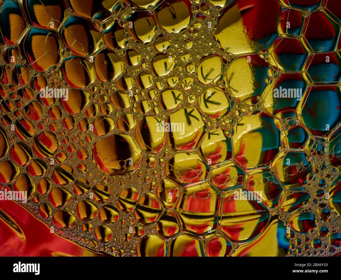 Conceptual close-up still-life of colourful bubbles on a liquid surface ...