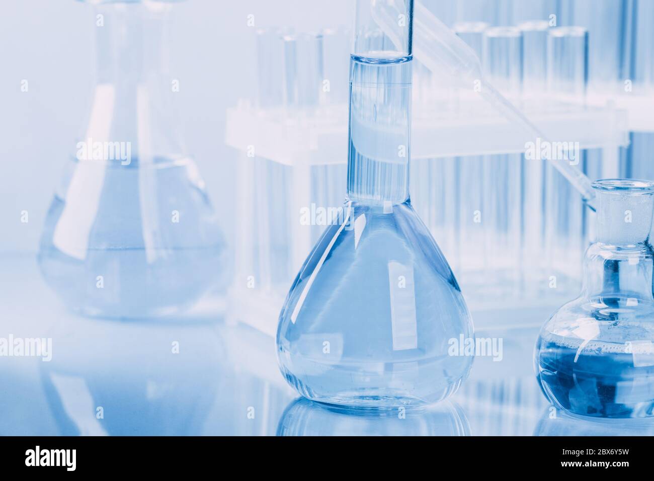 Laboratory glassware with a dropper dripping liquid into a test tube ...