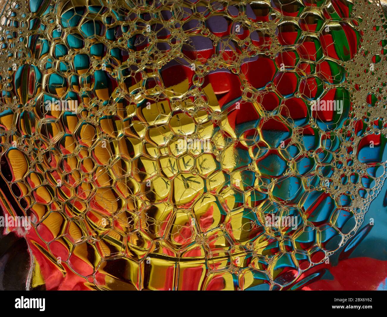 Conceptual close-up still-life of colourful bubbles on a liquid surface ...