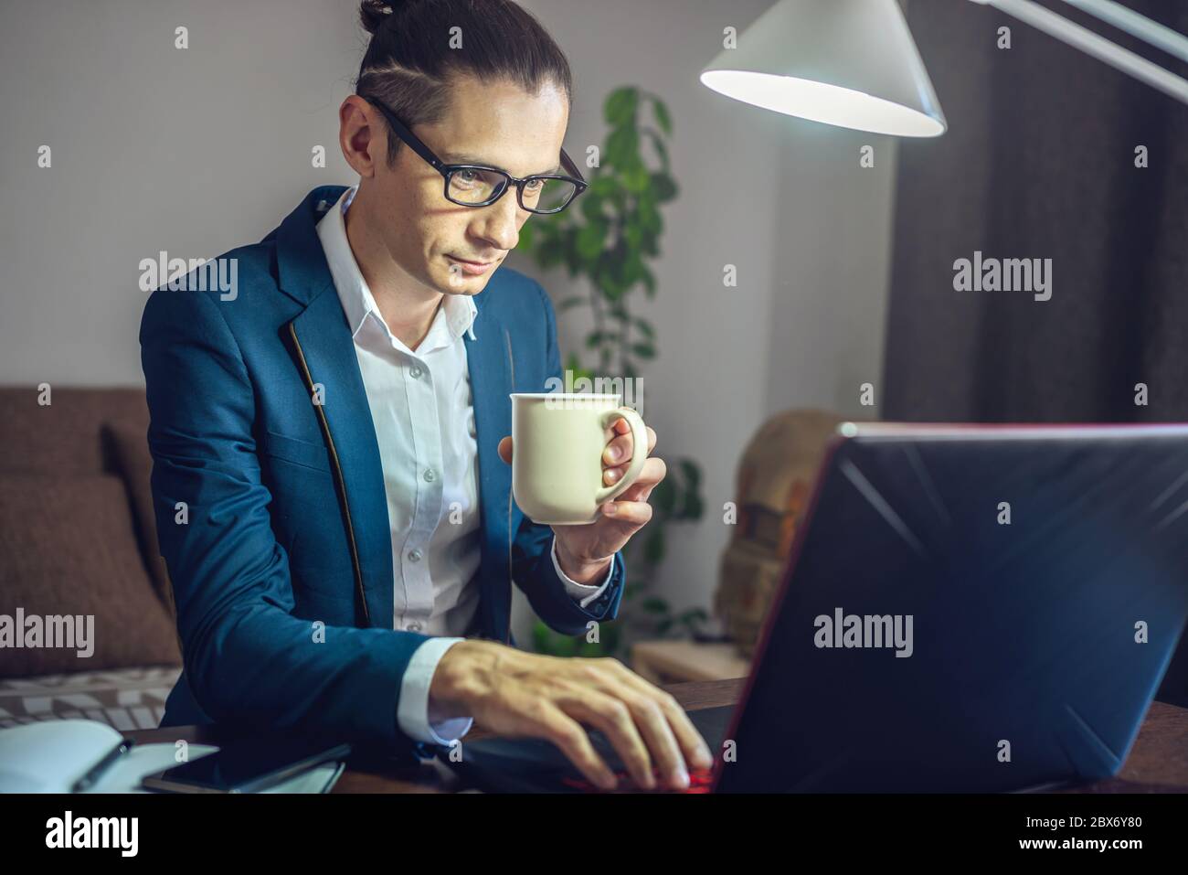 A male businessman is working remotely in home office mode. Online ...