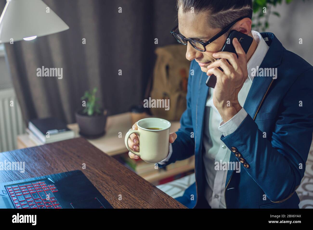 A male businessman is working remotely in home office mode. Online ...