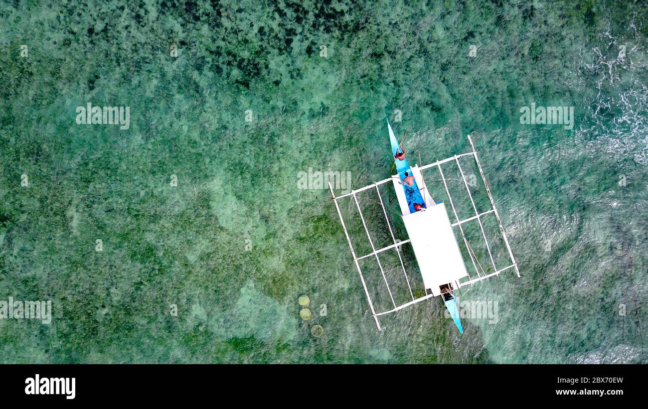 Aerial view of a fishing boat floating on the crystal clear water with ...