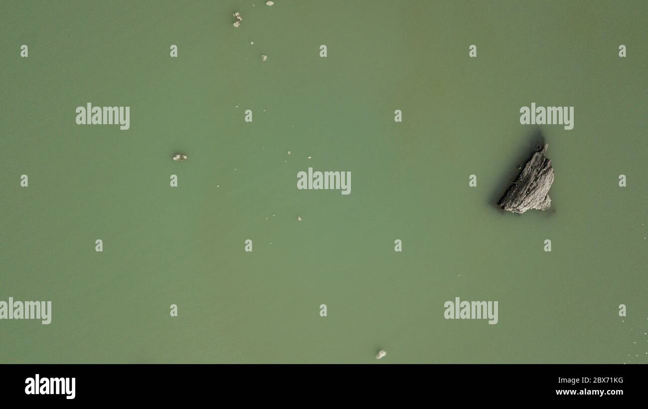 Aerial view on floating iceberg of Black Glaciar covered with volcanic ...