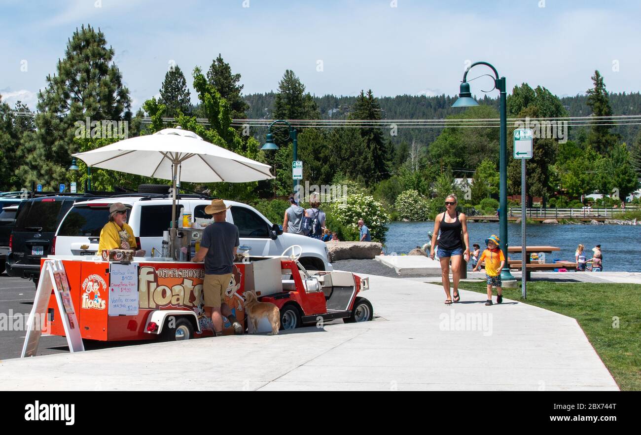 Warm spring day at downtown Bend Oregon public park with man selling ...