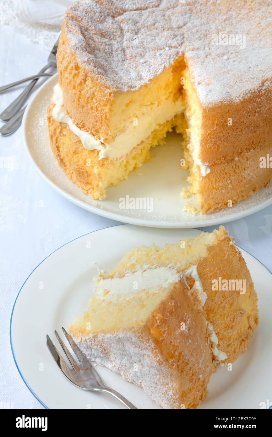 Cream sponge cake with slice cut out for serving Stock Photo - Alamy