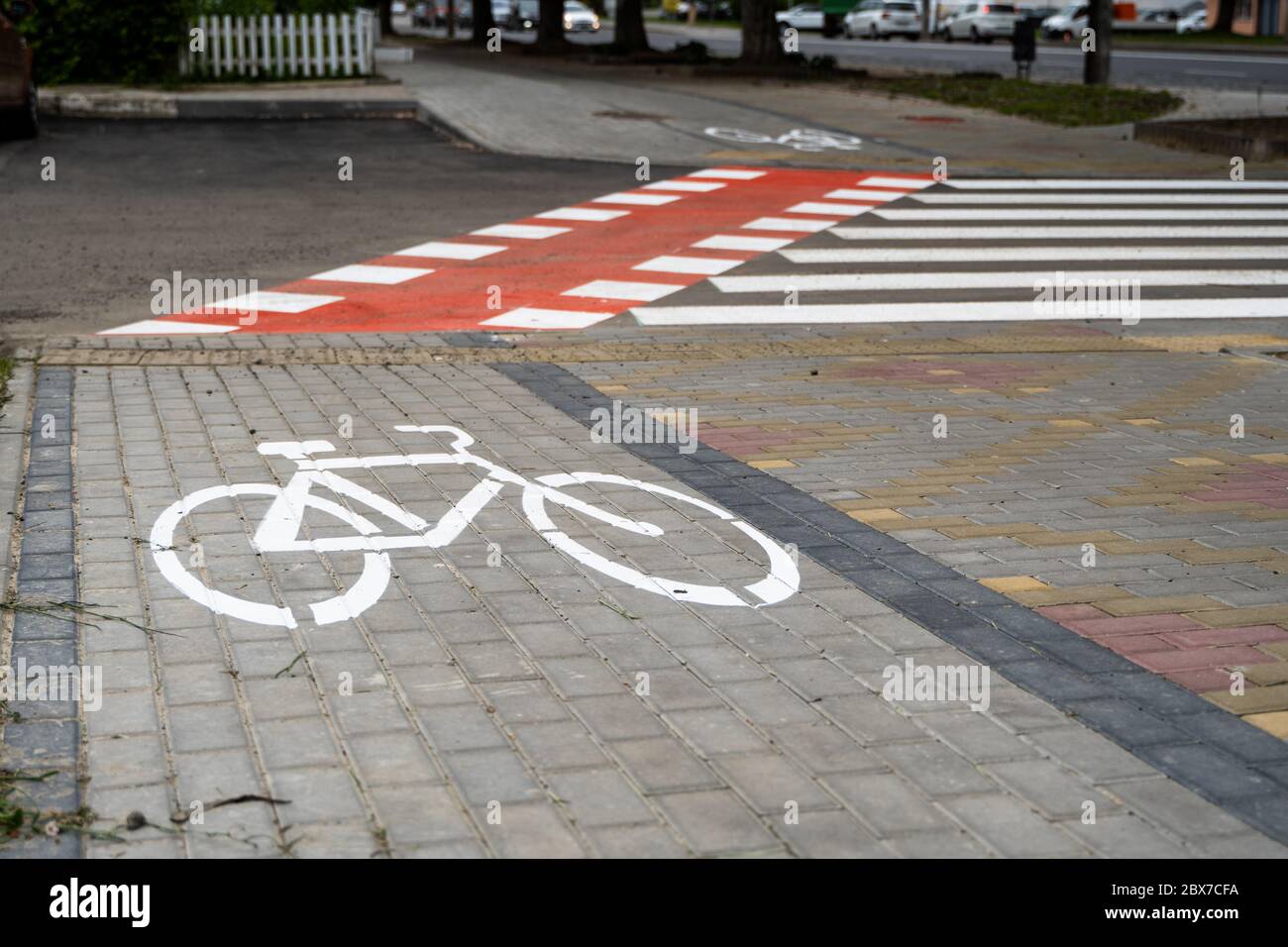Cycling path with a symbol of bike on a ground through avtomobile road ...