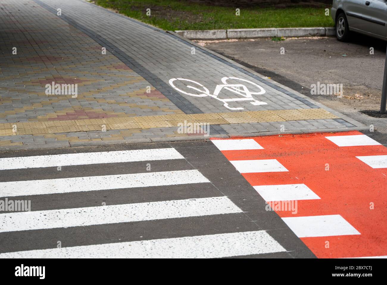 Cycling path with a symbol of bike on a ground through avtomobile road ...