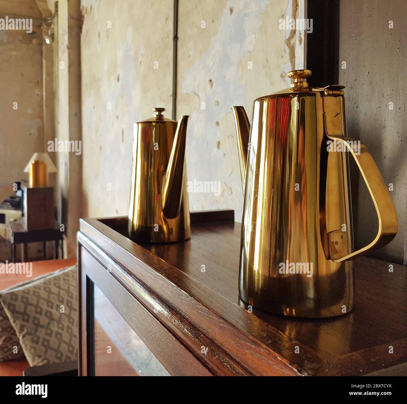 Two golg metal teapot in interior Stock Photo - Alamy