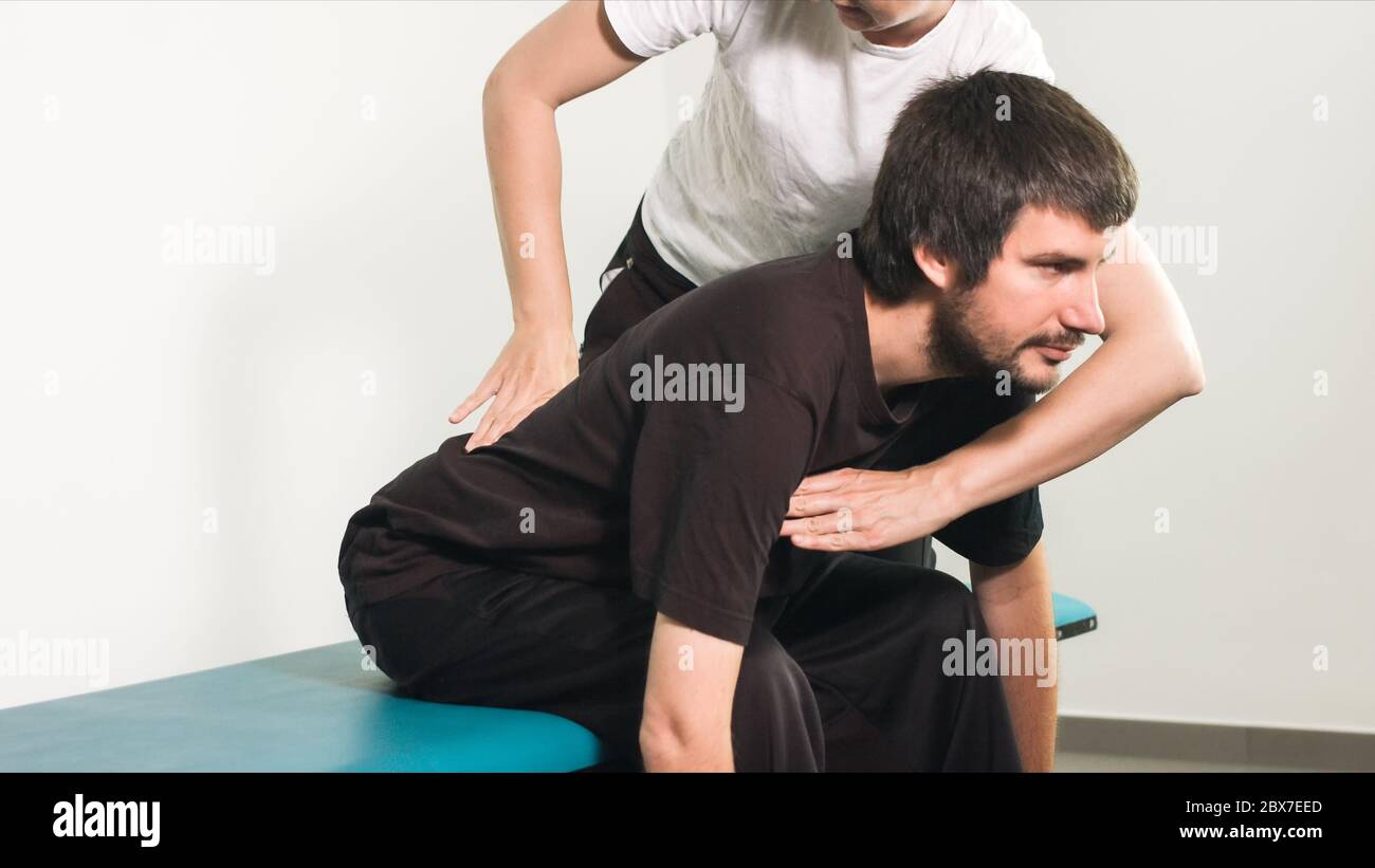 Physiotherapist exercising with disabled person on a therapy table ...