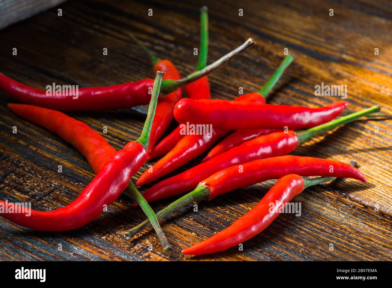 Pile of Mexican mini chili peppers on wooden background Stock Photo - Alamy