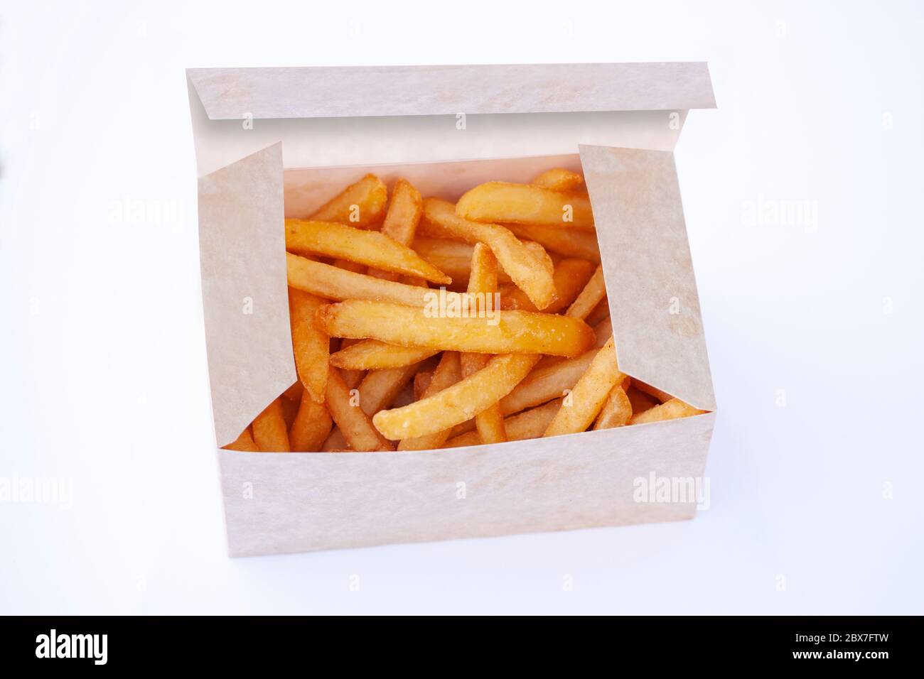 Pile of delicious golden and crunchy french fries in an open box made ...