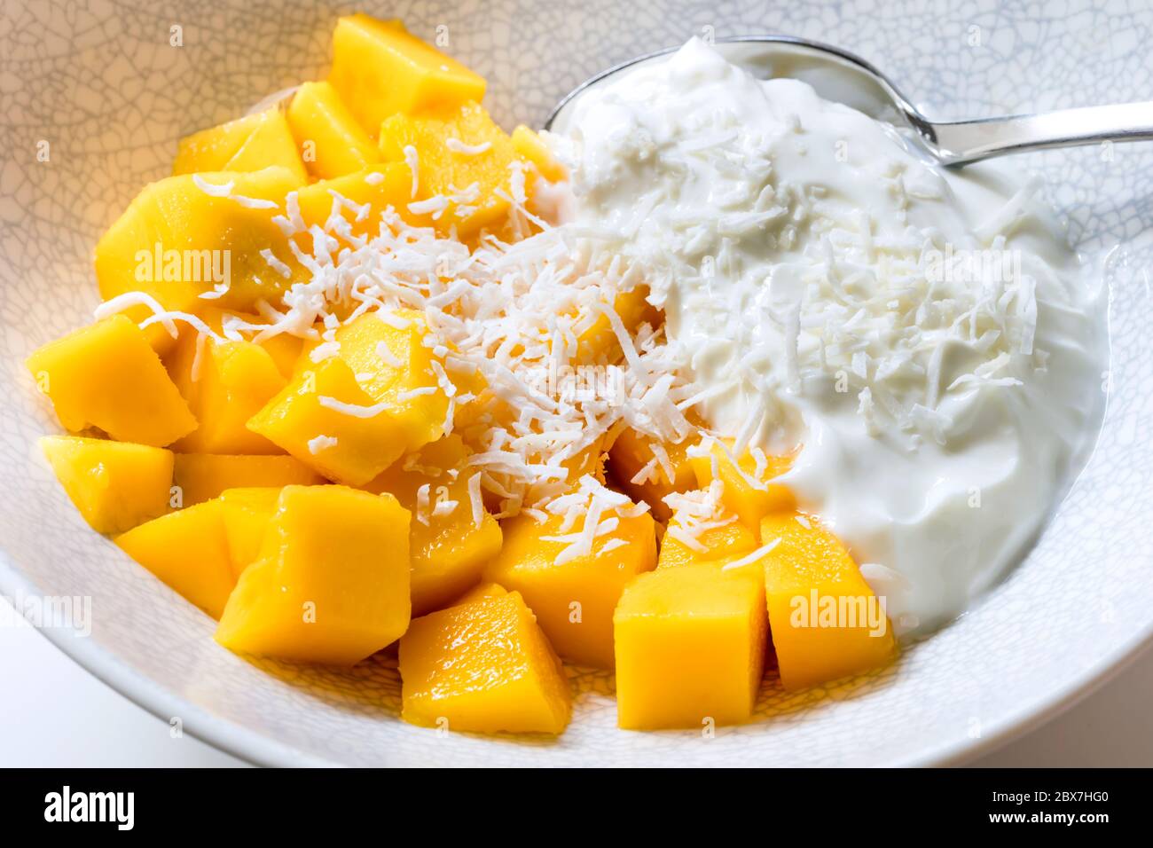 Fresh mango with yogurt and shredded coconut. Delicious healthy ...