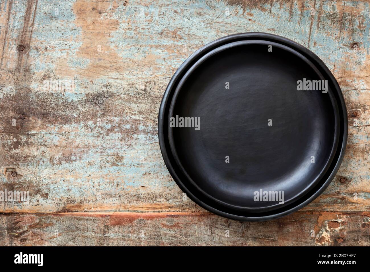 Empty rustic black plates over grunge textured timber, top view Stock ...
