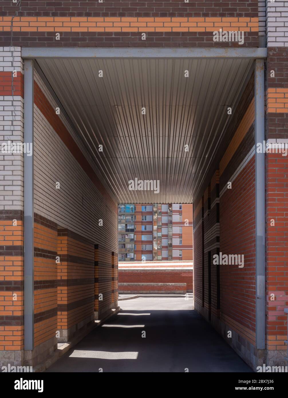 Narrow brick passage into the inner house of a multi-storey residential ...