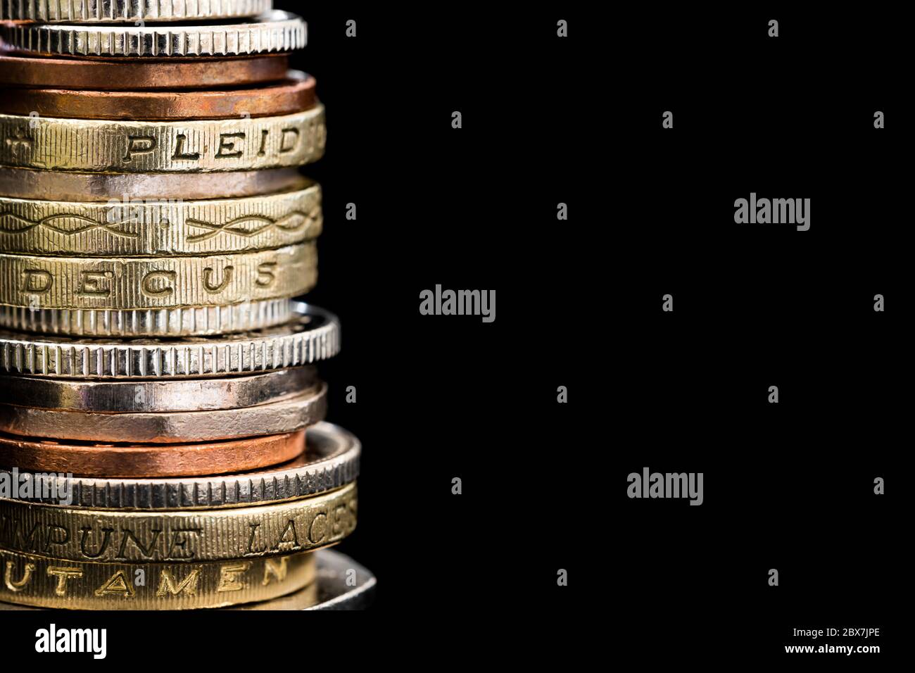 Stack of British coins over black. Finance background with copy space ...