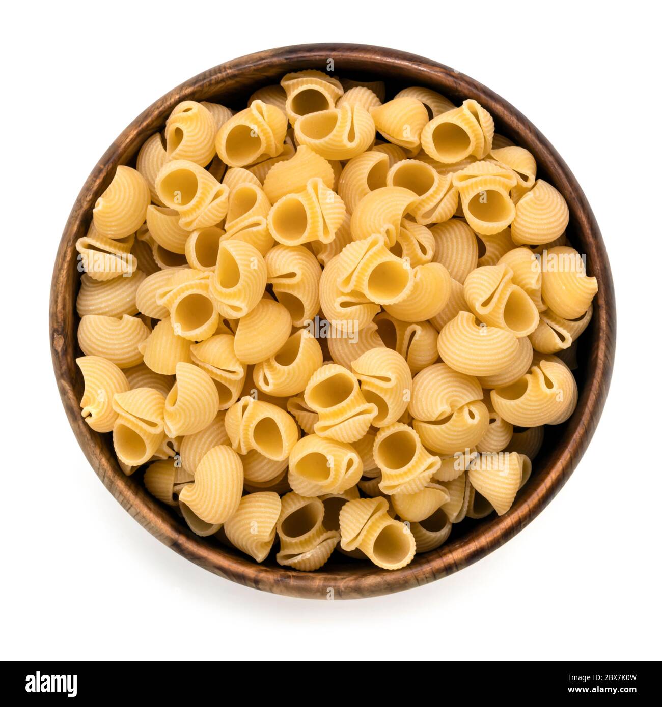 Raw pasta shells in wooden bowl, top view, isolated on white Stock ...