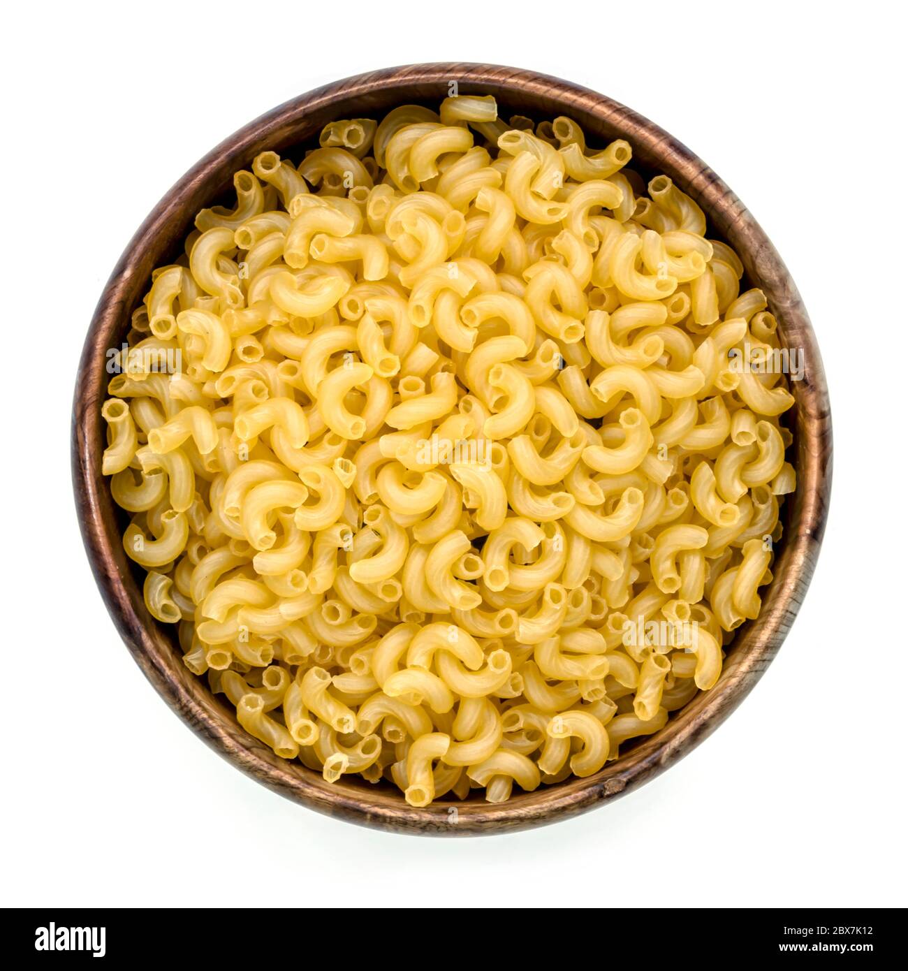 Raw pasta macaroni elbows in wooden bowl, top view, isolated on white ...