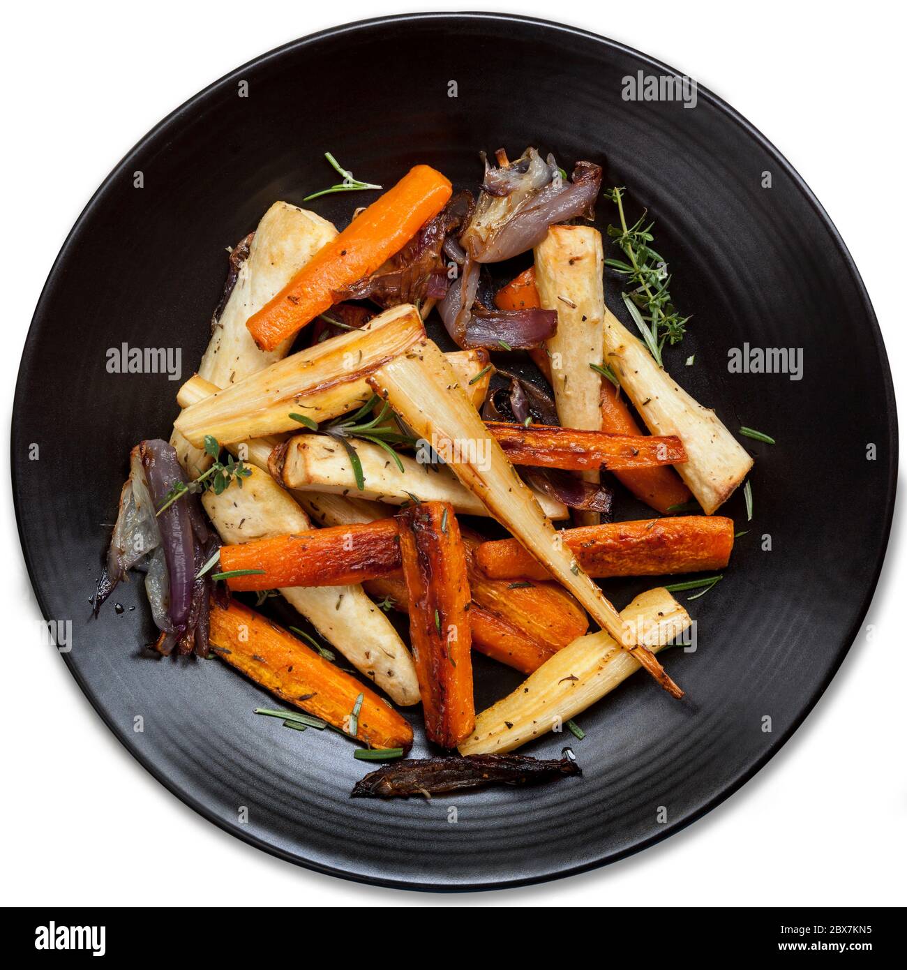 Roasted root vegetables in black platter, isolated. Top view Stock ...