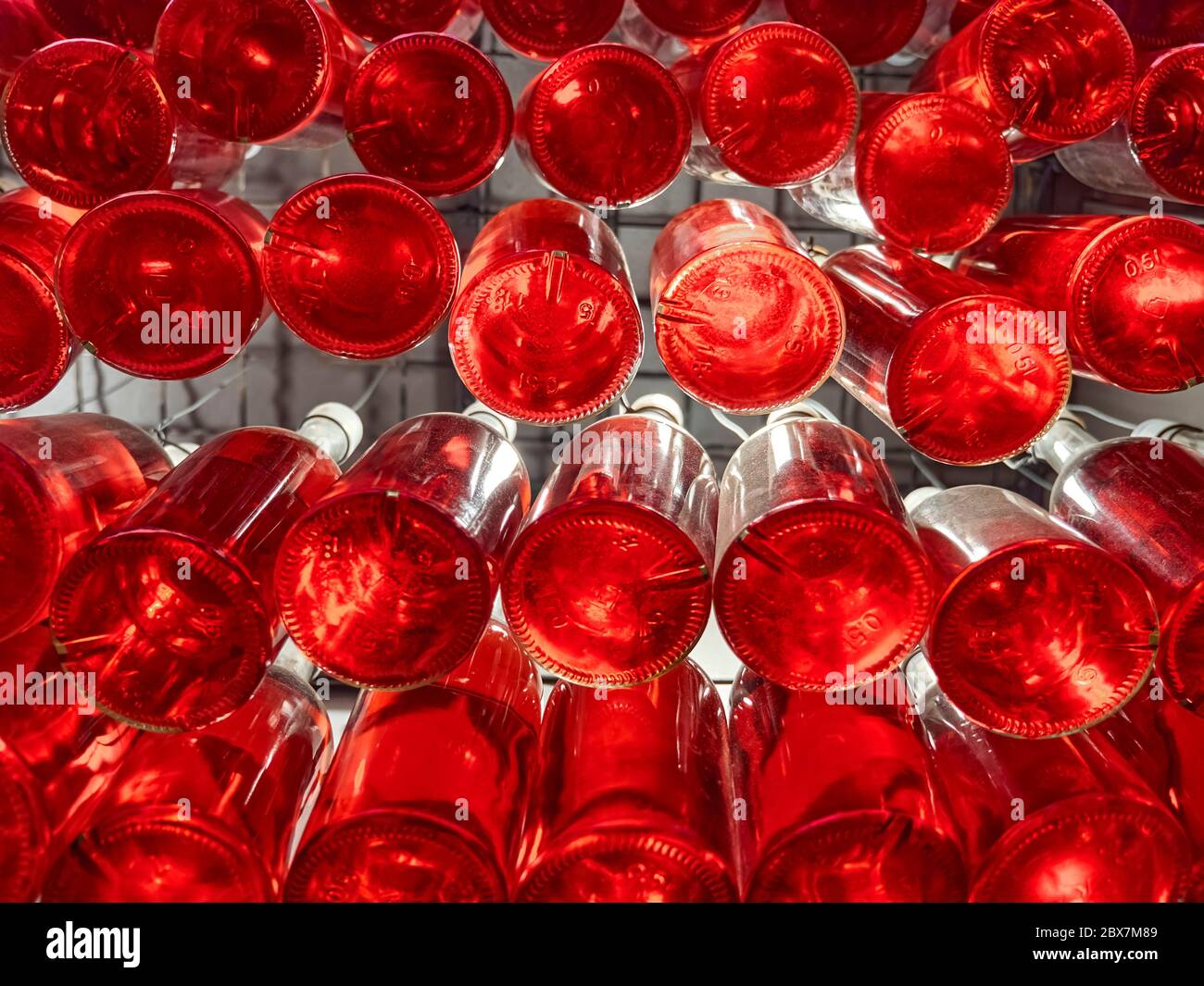 Bottles with beverage. Bottoms of the bottles with red drink. Many ...