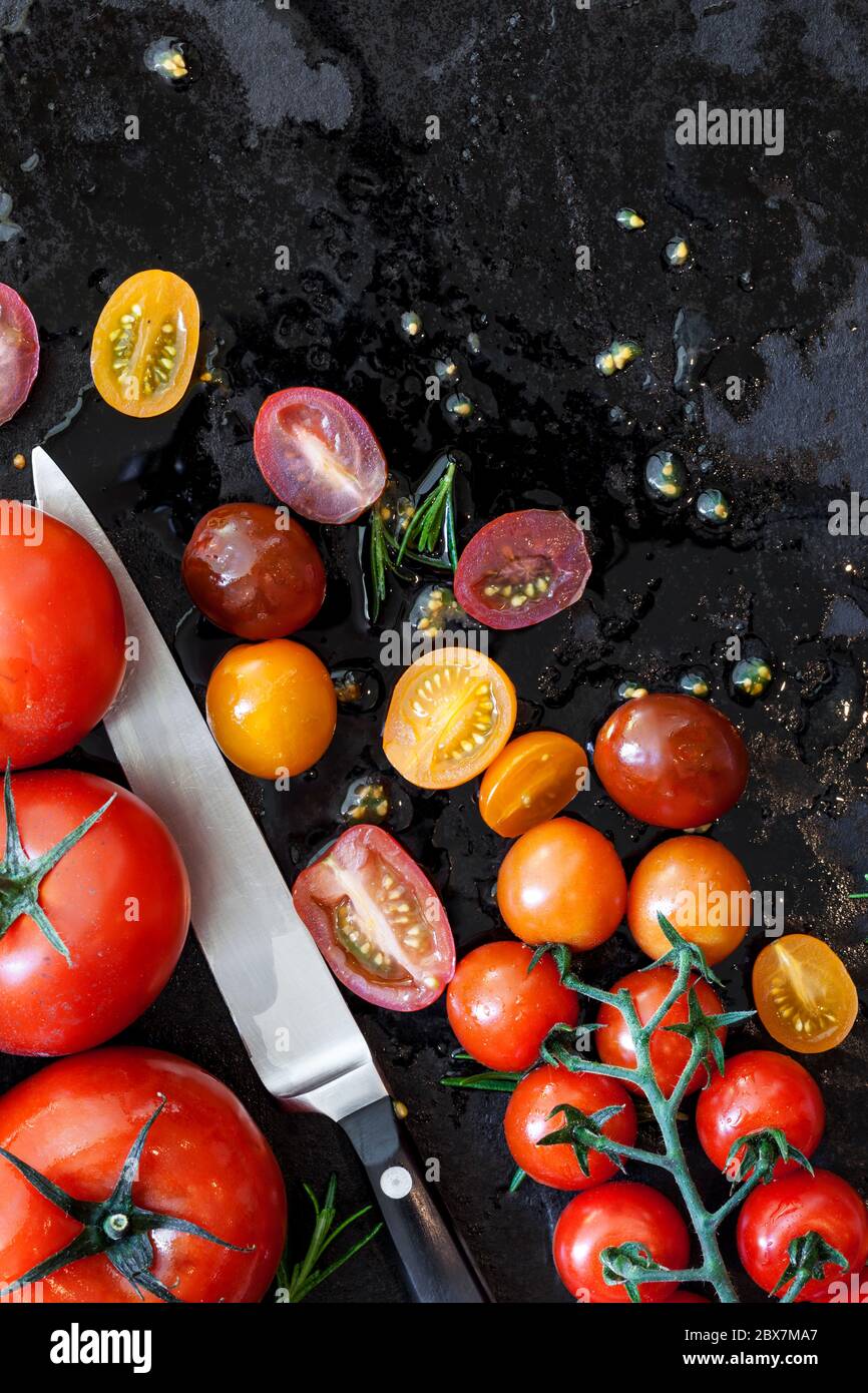 Tomato varieties on black iron. Overhead view Stock Photo - Alamy