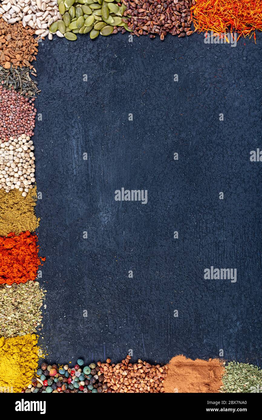 Frame made of different organic spices on black dark background, top ...