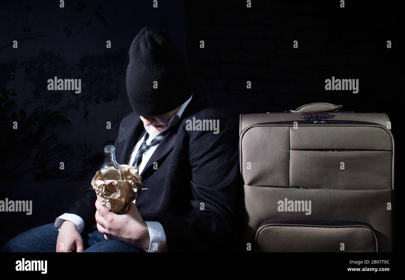 Photo of a drunk homeless business man sitting with empty bottle and ...