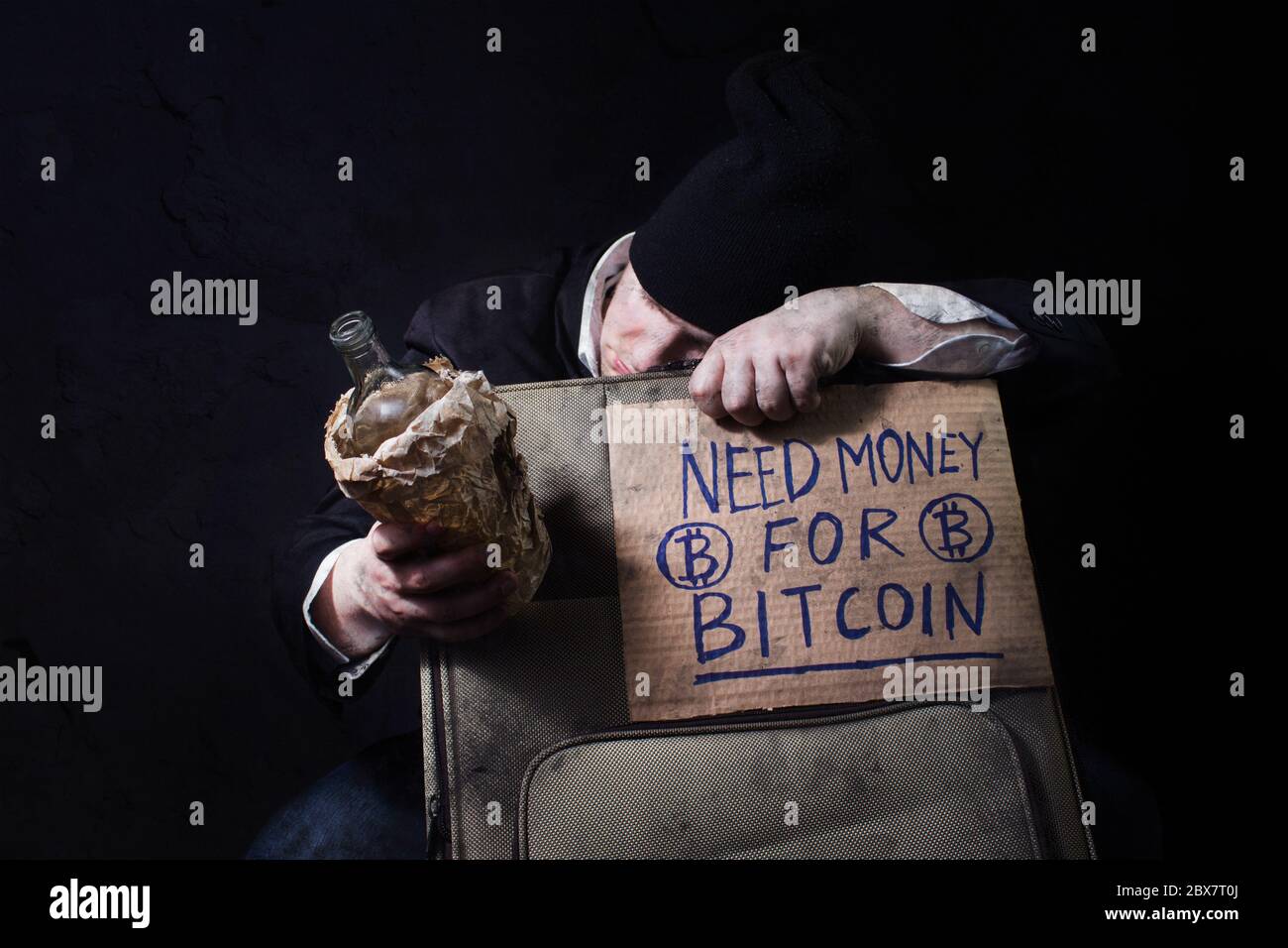 Homeless business man sleeping on travel suitcase with empty bottle and ...