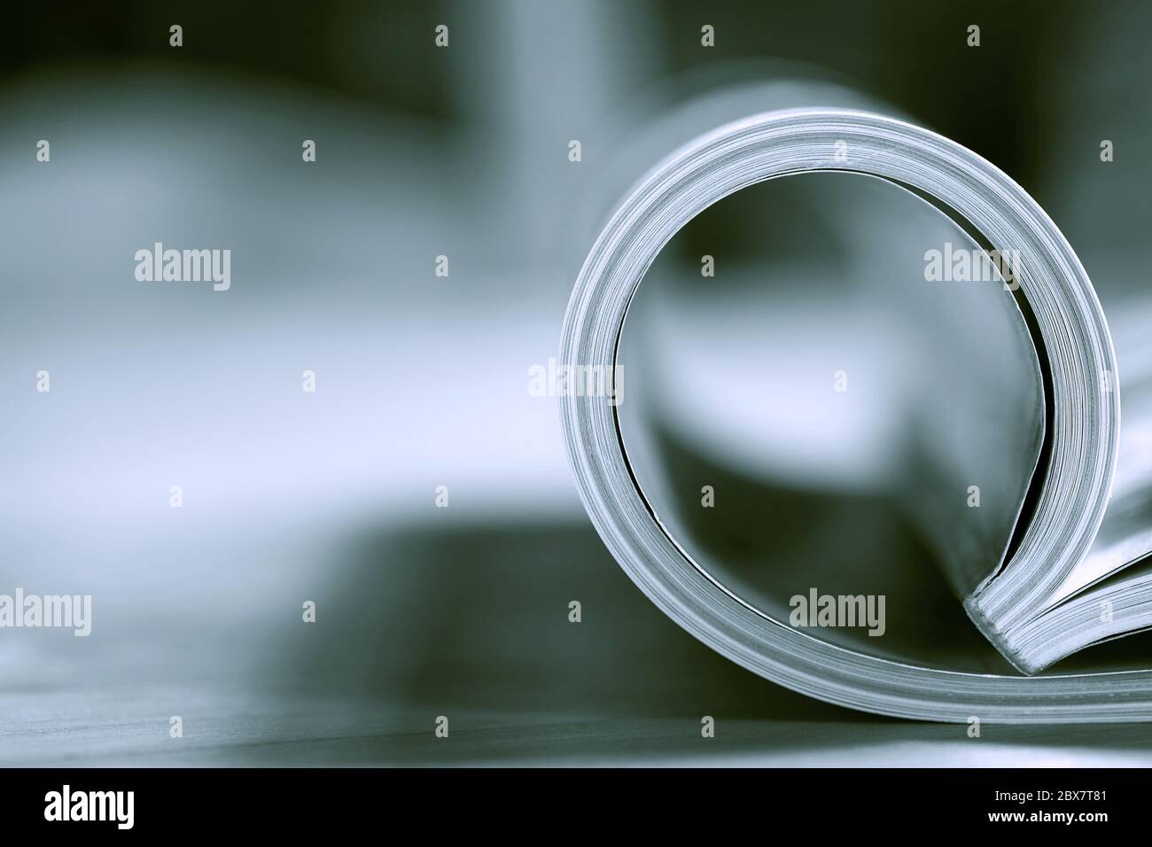 Rolled magazine, with lots of room for text. Blue tone Stock Photo - Alamy
