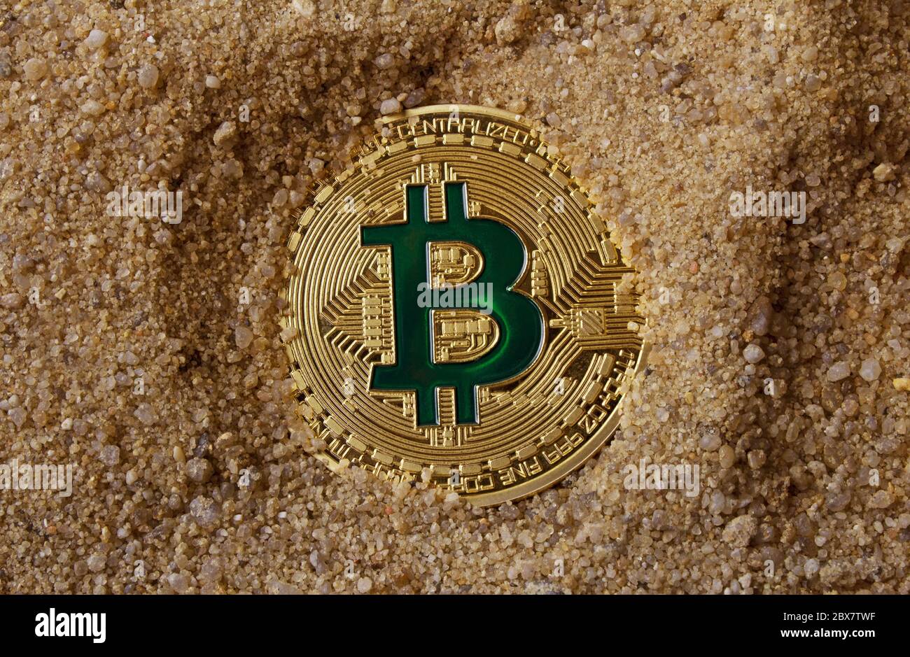 Photo of a golden bitcoin coin laying in sand Stock Photo - Alamy