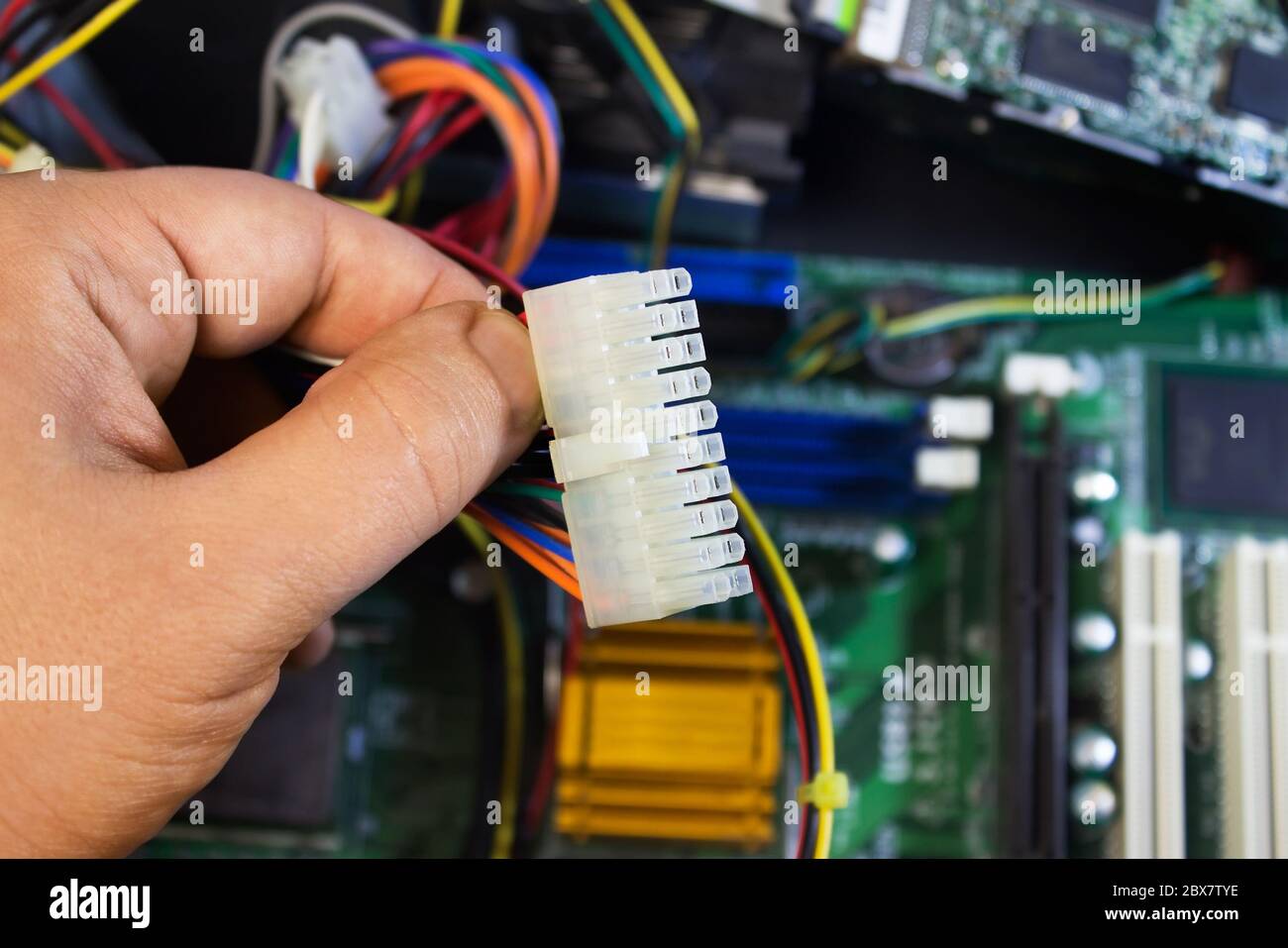 First person view hands holding ide power cable on motherboard ...