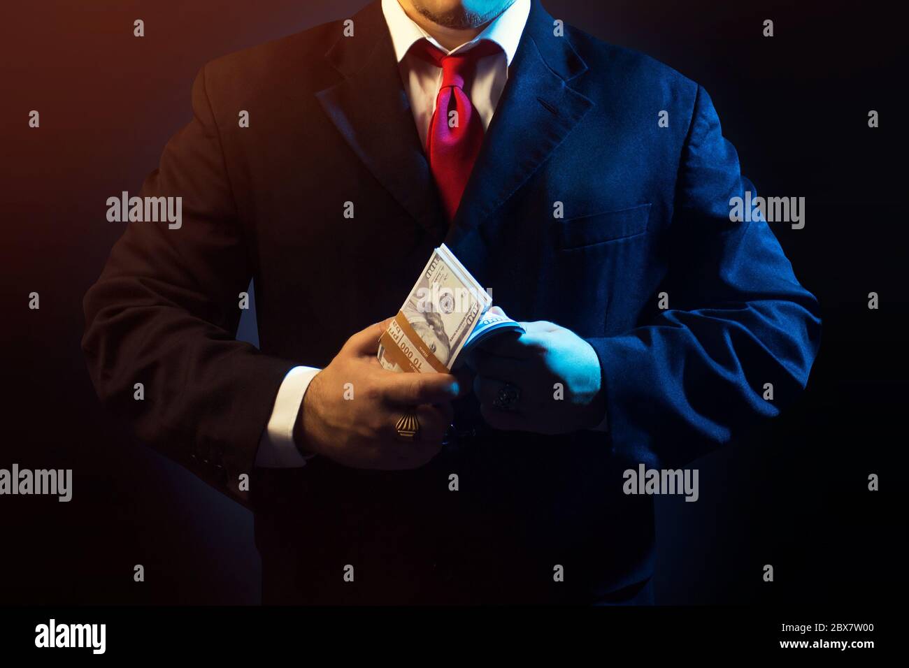 Mafia man in suit counting money on black background Stock Photo - Alamy