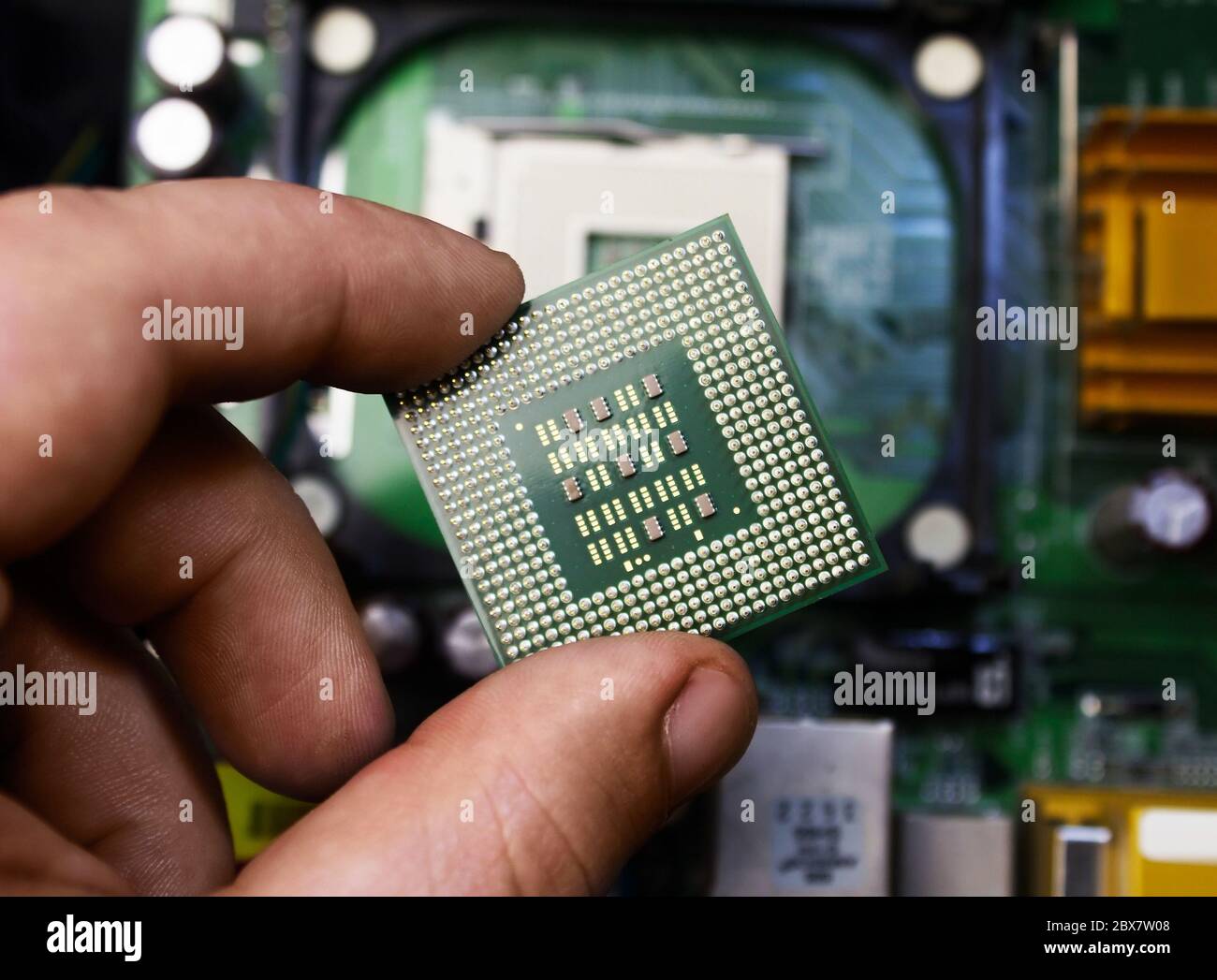 First person view hand holding a computer processor chip on motherboard ...